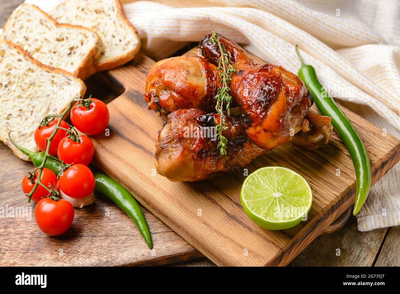 Board with roasted chicken legs on wooden background Stock Photo - Alamy