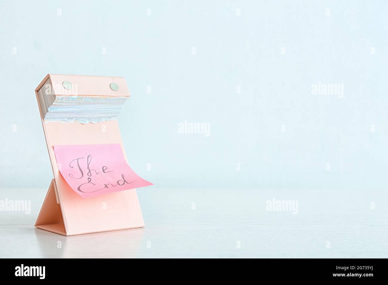 Tear-off calendar with text THE END on color background Stock Photo - Alamy