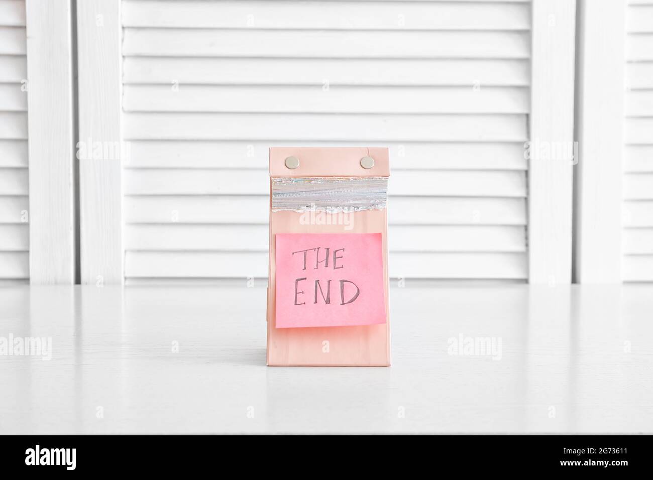 Tear-off calendar with text THE END on light background Stock Photo - Alamy