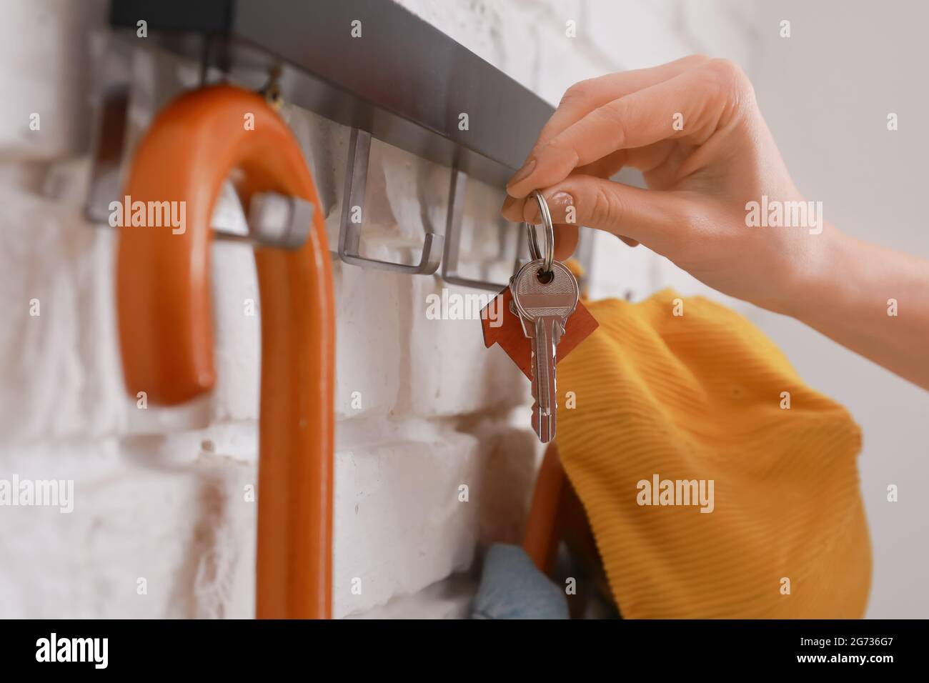 Woman hanging key on rack, closeup Stock Photo - Alamy