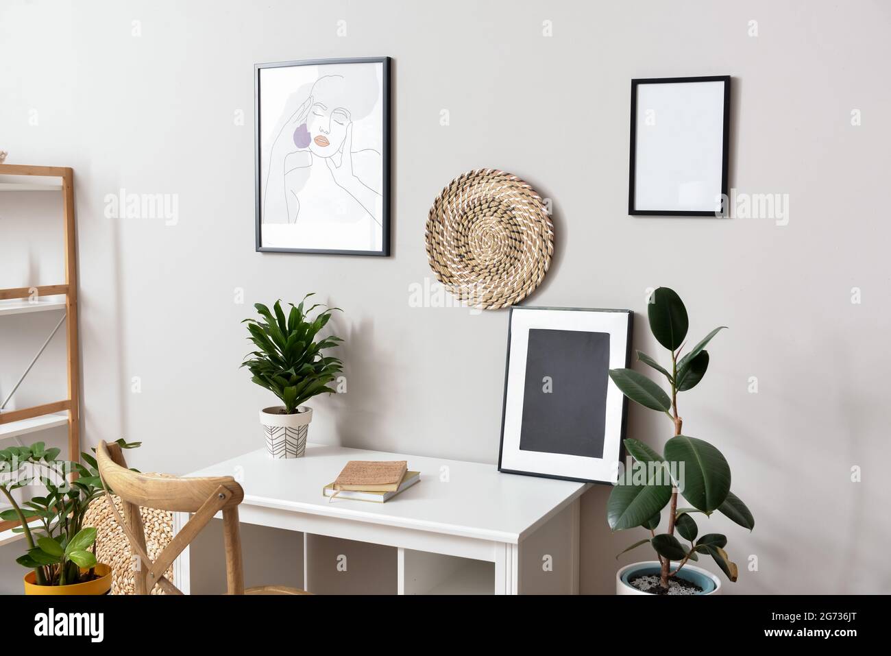 Modern workplace with frames near light wall Stock Photo - Alamy