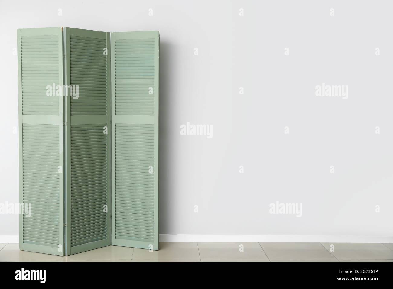 Modern folding screen near light wall Stock Photo - Alamy