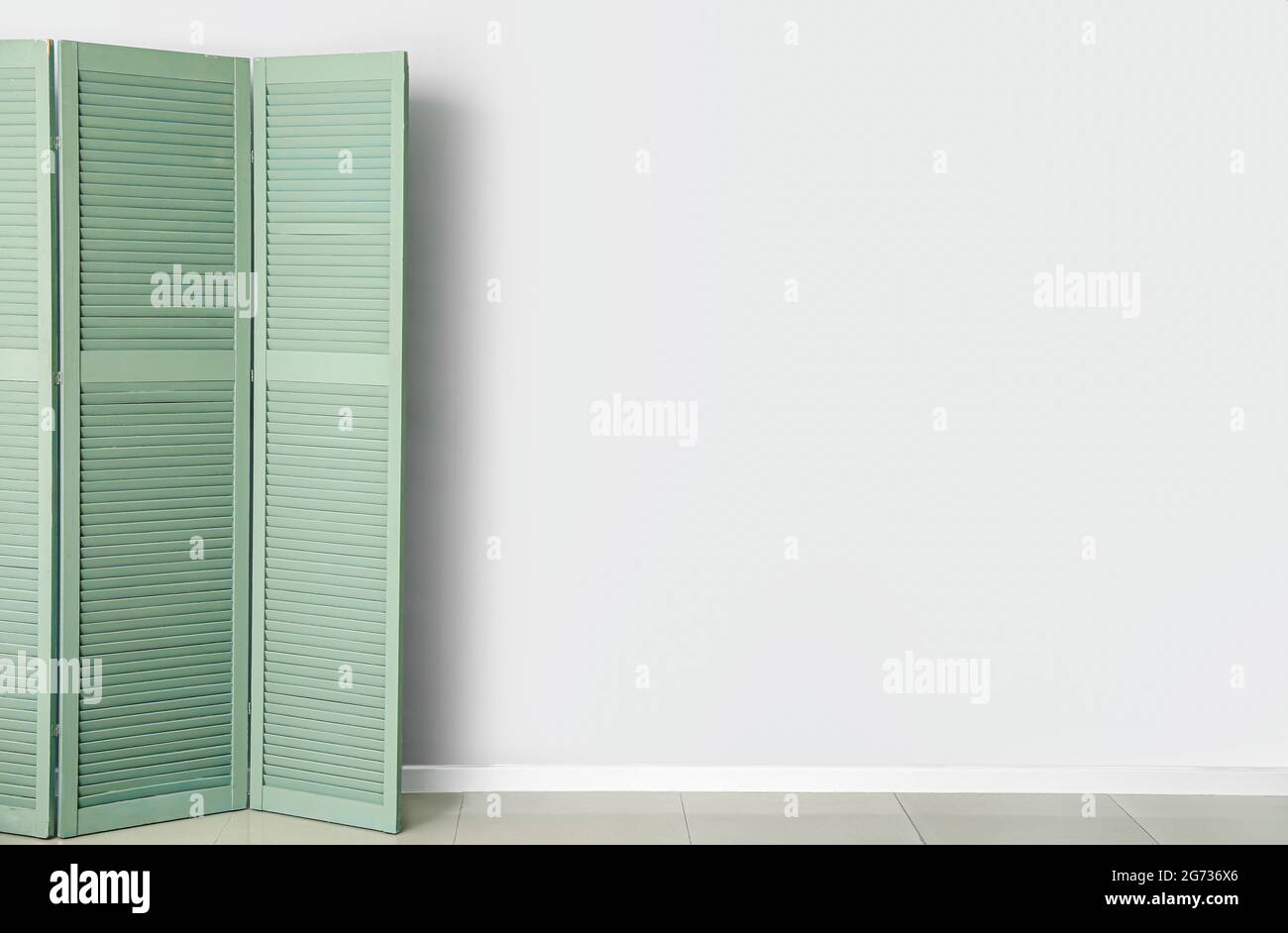 Modern folding screen near light wall Stock Photo - Alamy