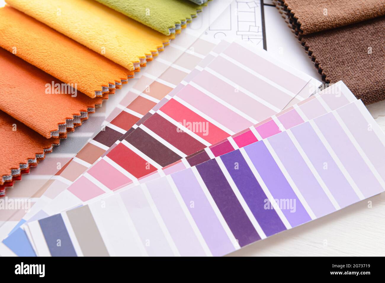 Paint color palettes and fabric samples on white background, closeup ...