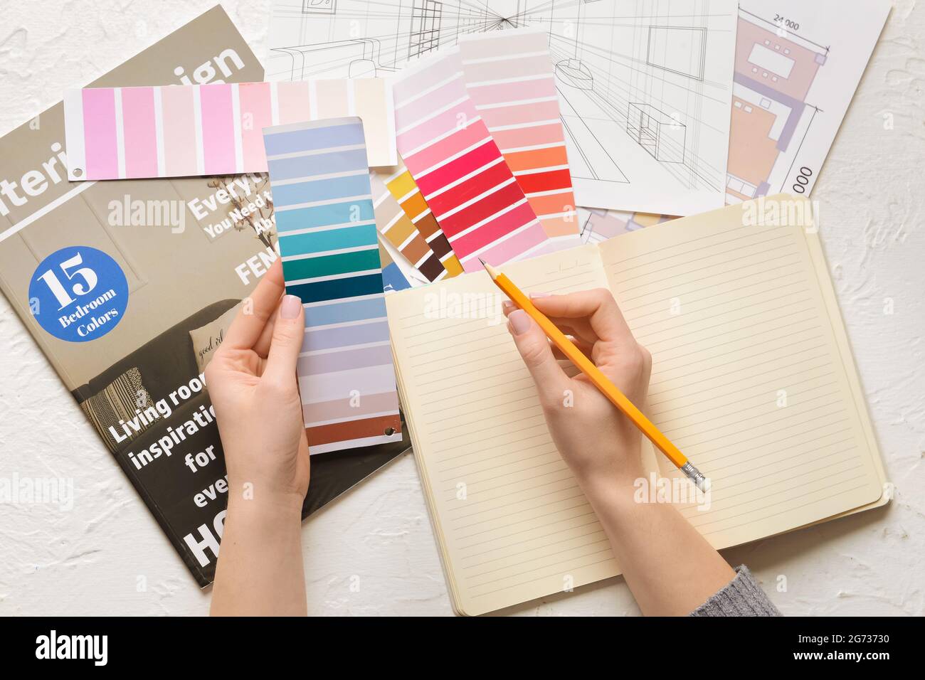 Woman with paint color palette writing in notebook on white background ...