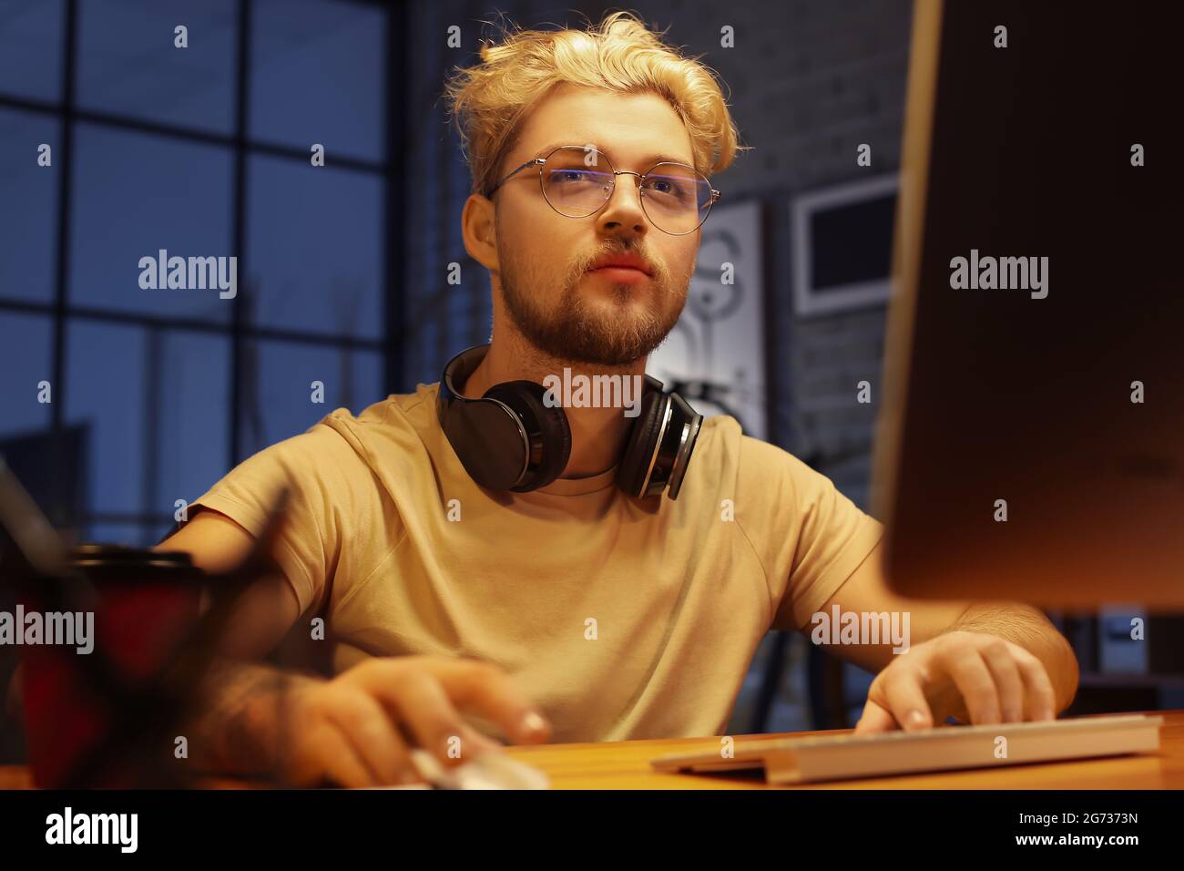 Male programmer working with computer late in evening Stock Photo - Alamy