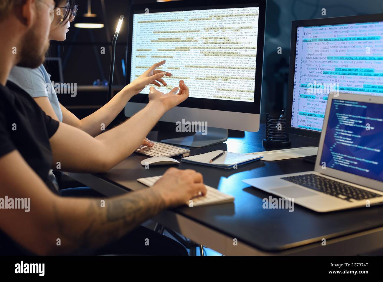 Young programmers working with computer in office at night Stock Photo - Alamy