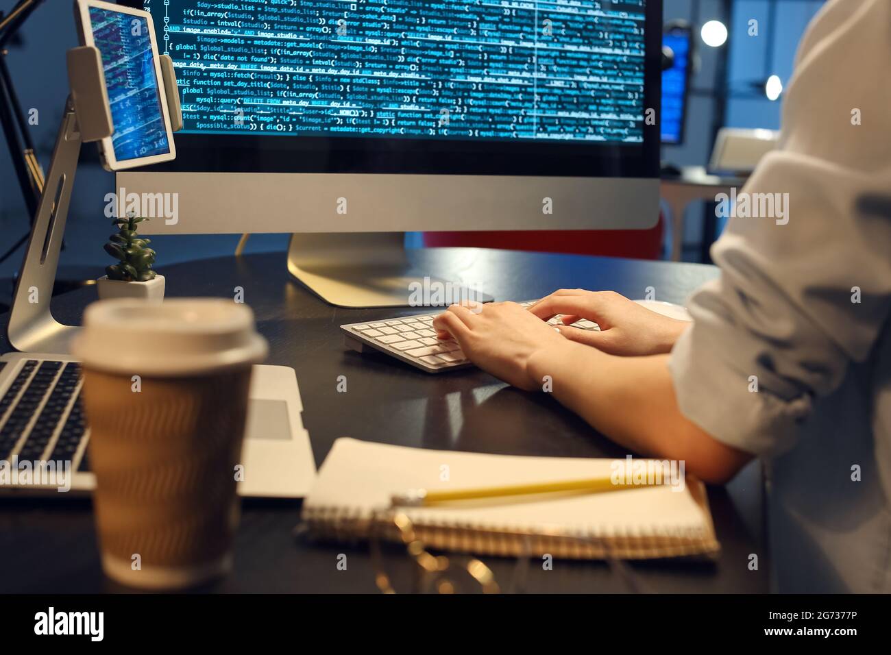 Female programmer working with computer in office at night Stock Photo ...