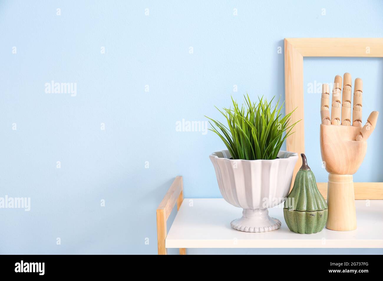 Wooden hand and decor on shelf near color wall Stock Photo - Alamy