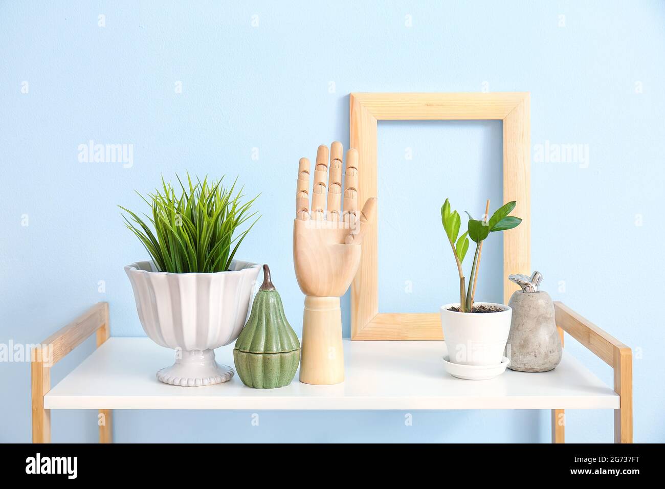 Wooden hand and decor on shelf near color wall Stock Photo - Alamy