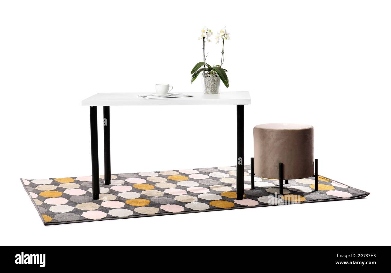 Stylish table with pouf and rug on white background Stock Photo - Alamy