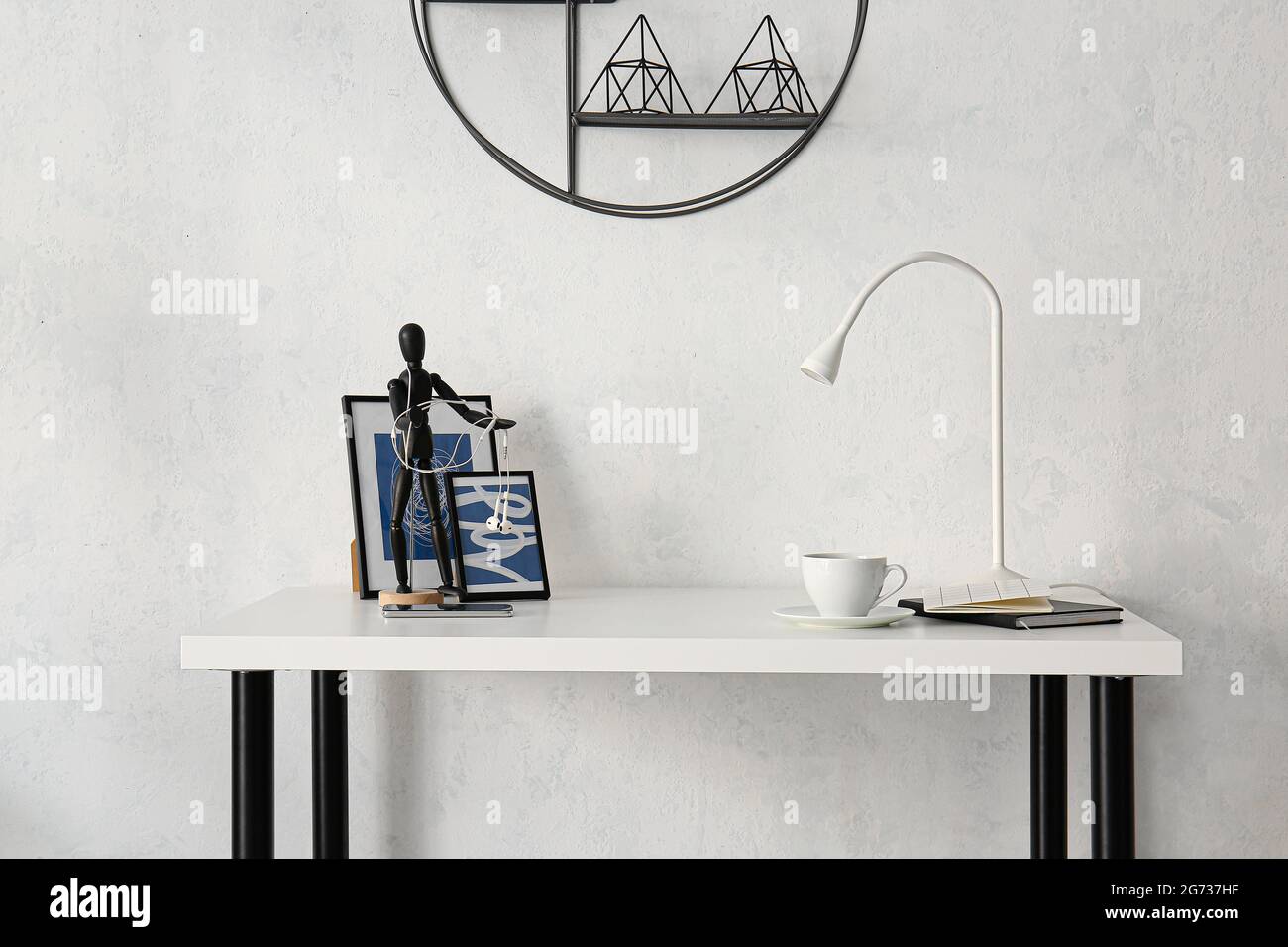 Modern workplace with lamp near light wall Stock Photo - Alamy