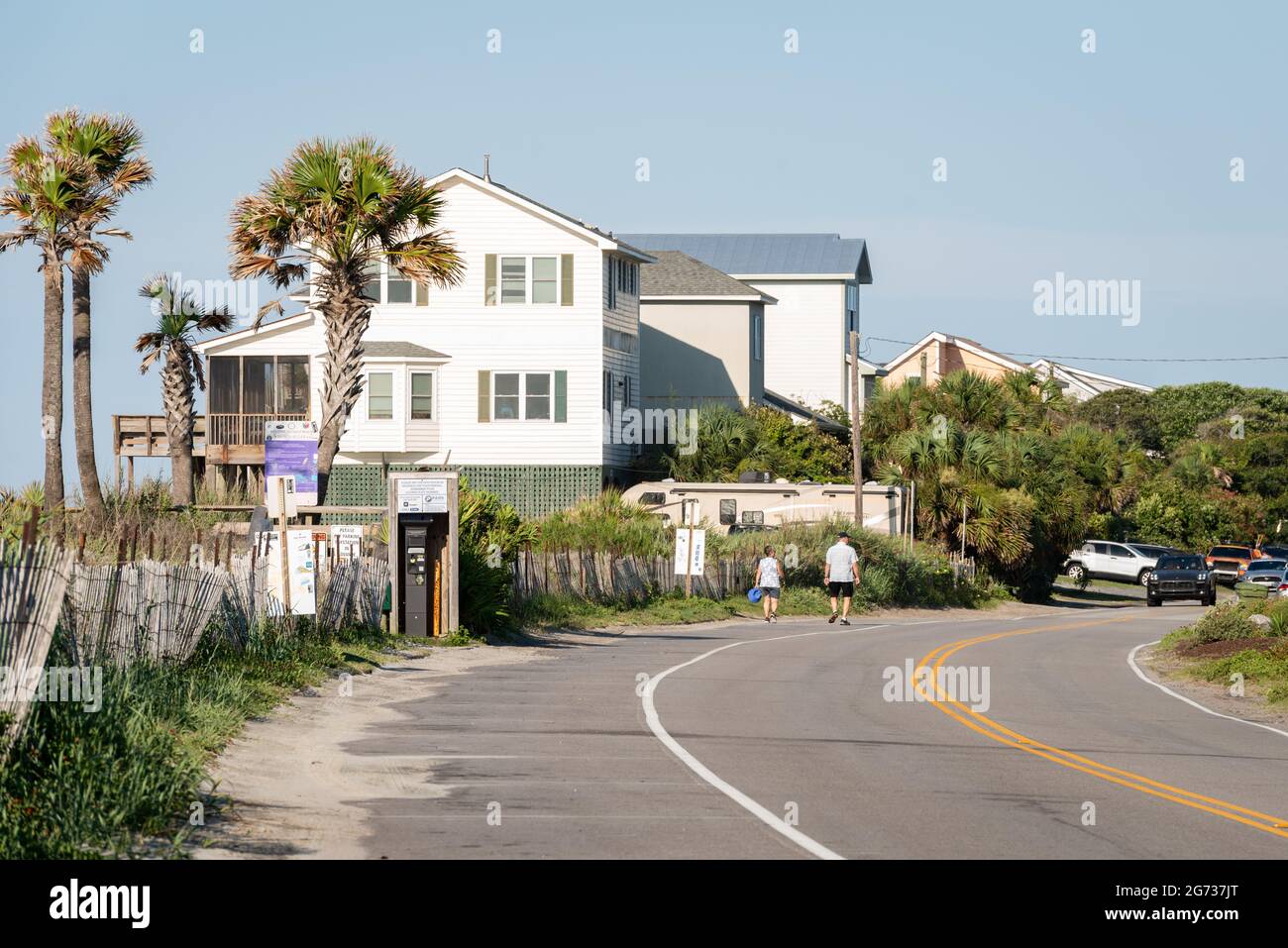 Pedestrians enjoy a morning walk in Folly Beach, South Carolina near ...