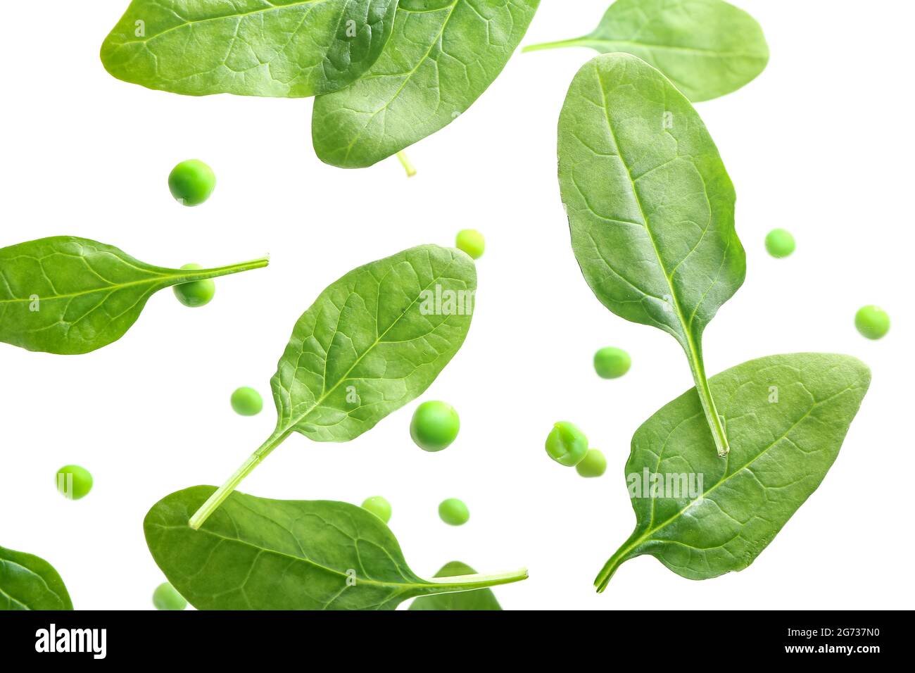 Flying peas and spinach on white background Stock Photo - Alamy