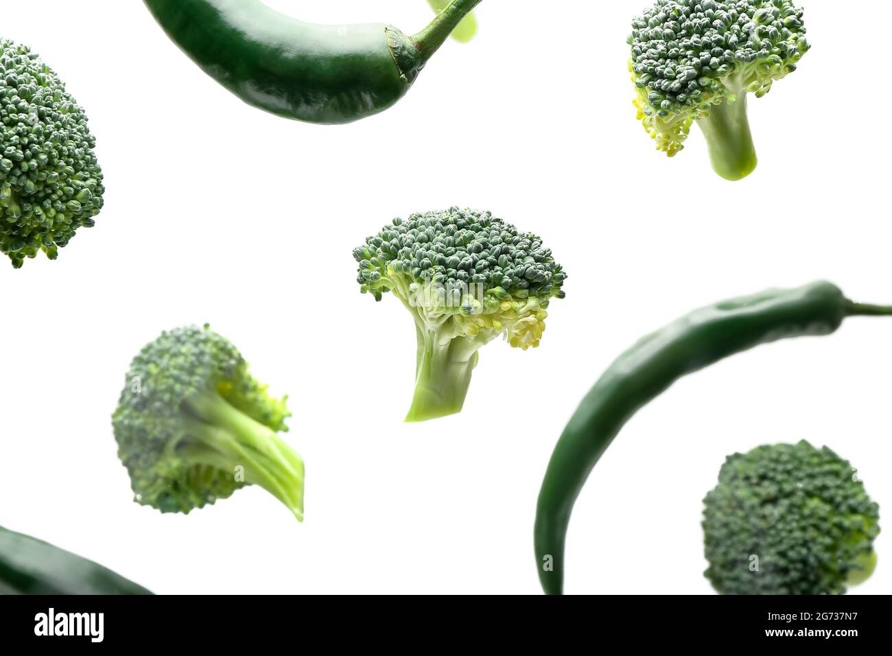 Flying chili peppers and broccoli on white background Stock Photo - Alamy