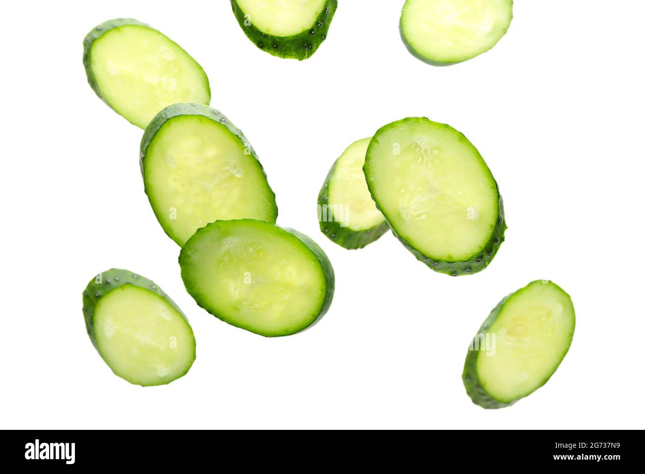 Flying cut cucumbers on white background Stock Photo - Alamy