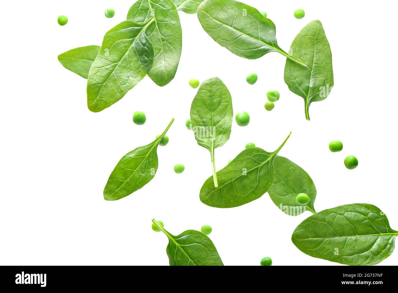 Flying peas and spinach on white background Stock Photo - Alamy