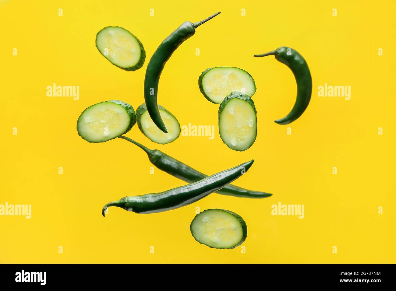 Flying cucumber slices and chili peppers background Stock Photo - Alamy