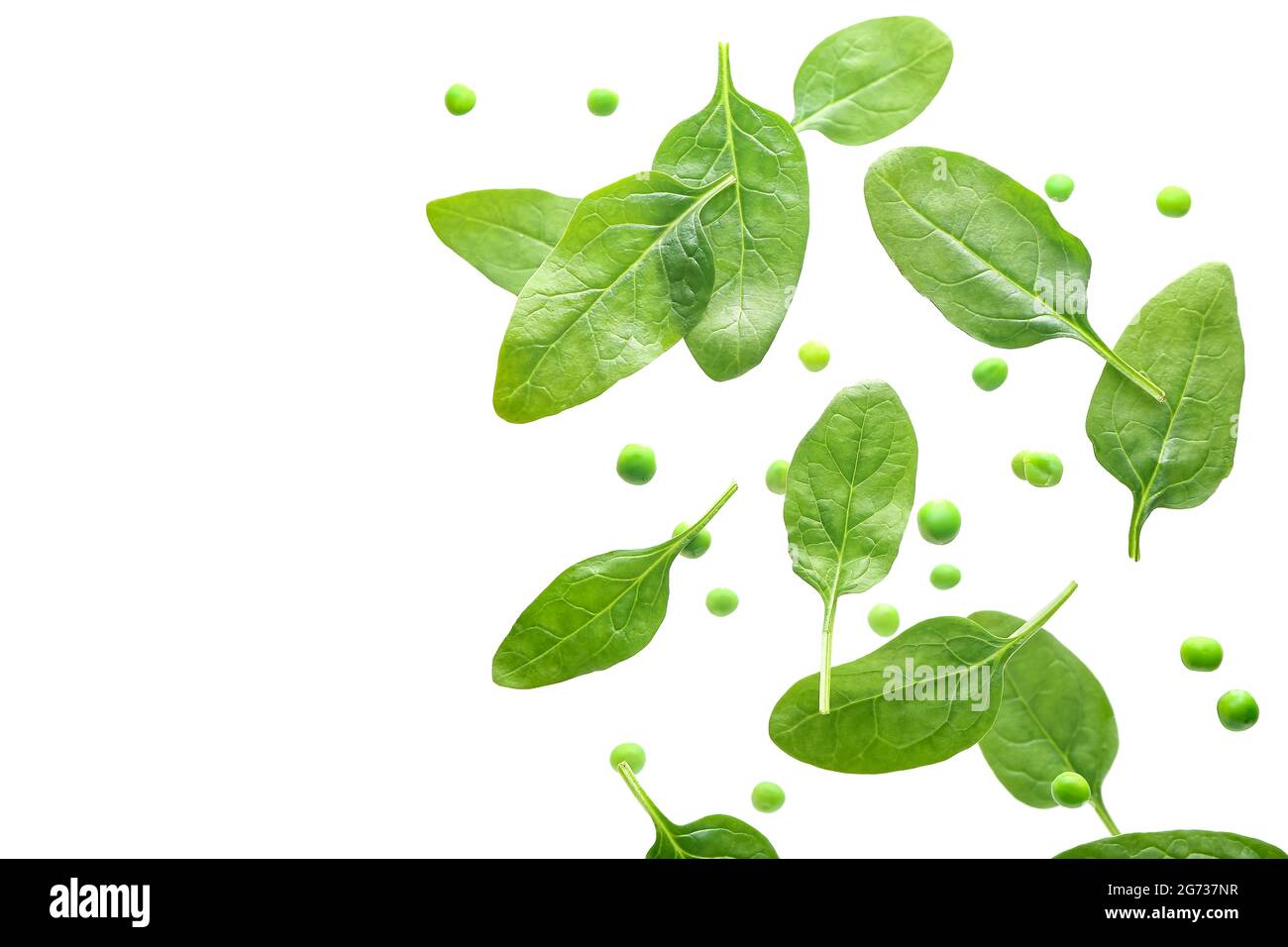 Flying peas and spinach on white background Stock Photo - Alamy