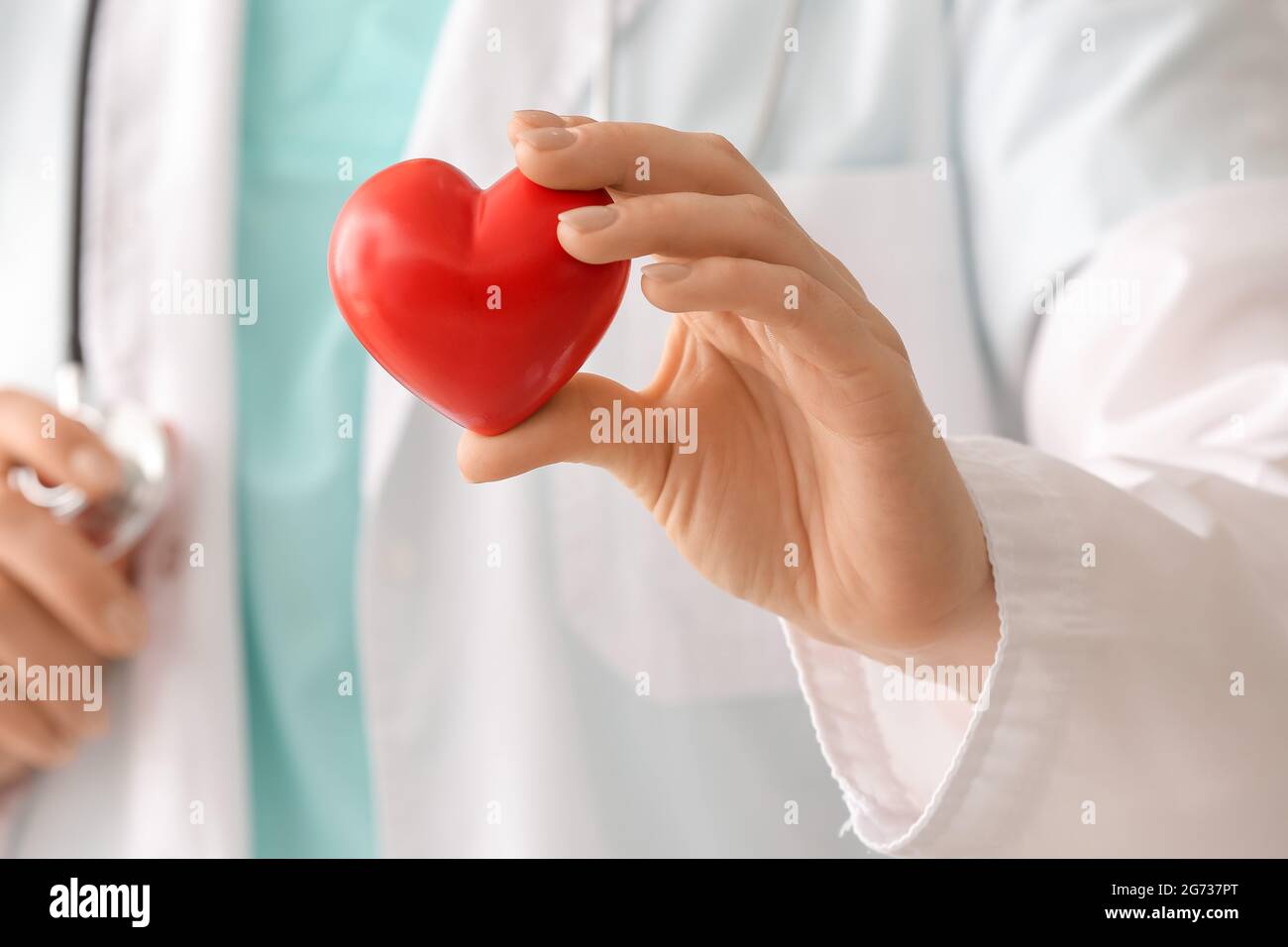 Female cardiologist with red heart, closeup Stock Photo - Alamy