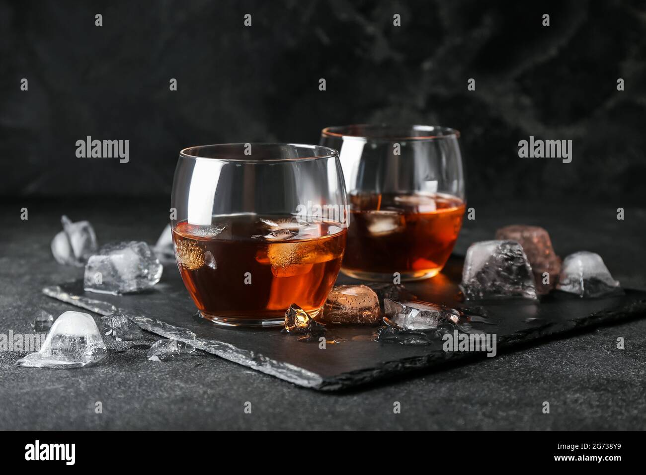 Glasses of cold whiskey on dark background Stock Photo - Alamy