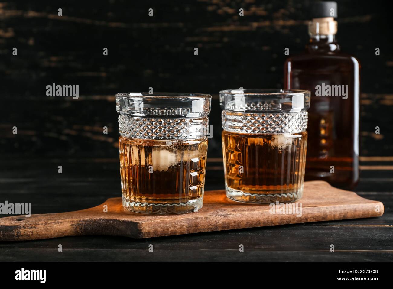 Glasses of cold whiskey on dark wooden background Stock Photo - Alamy