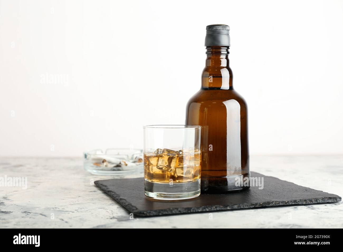 Bottle and glass of cold whiskey on light background Stock Photo - Alamy