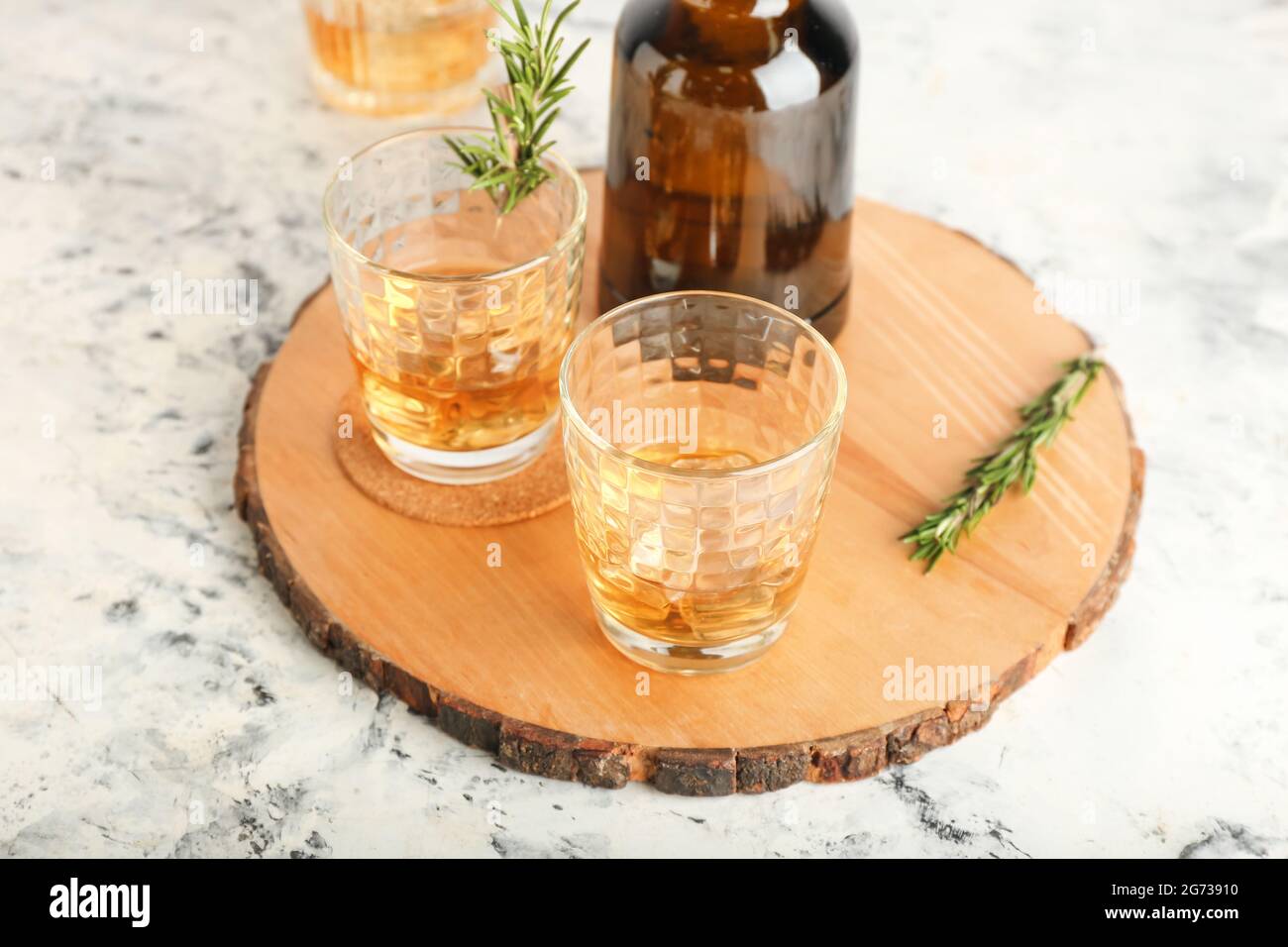 Bottle and glasses of cold whiskey on light background Stock Photo - Alamy