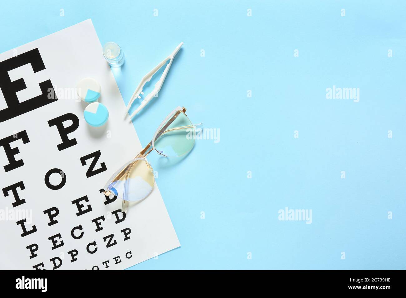 Composition with eyeglasses and eye test chart on color background ...