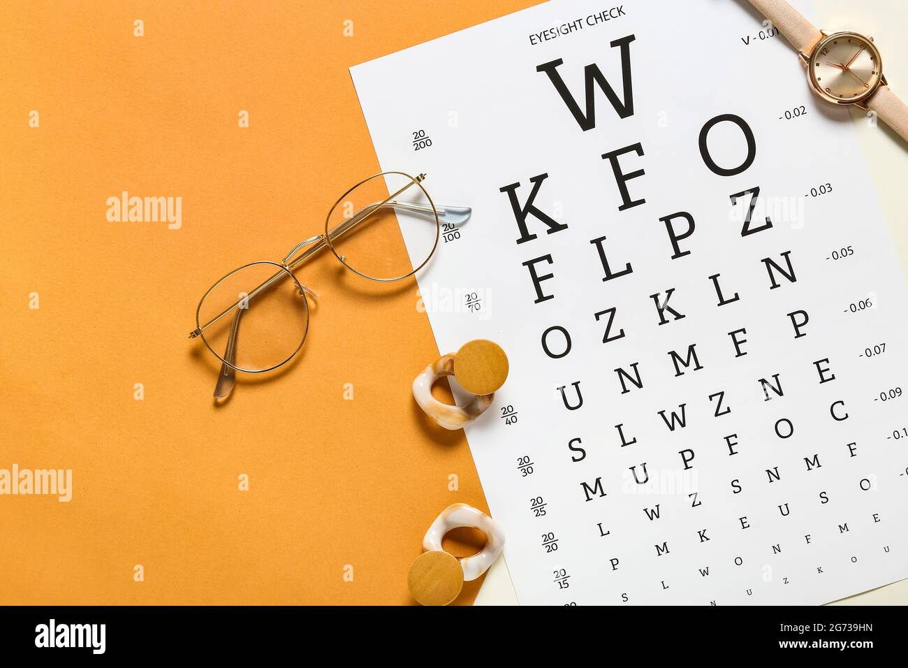Composition with eyeglasses and eye test chart on color background ...