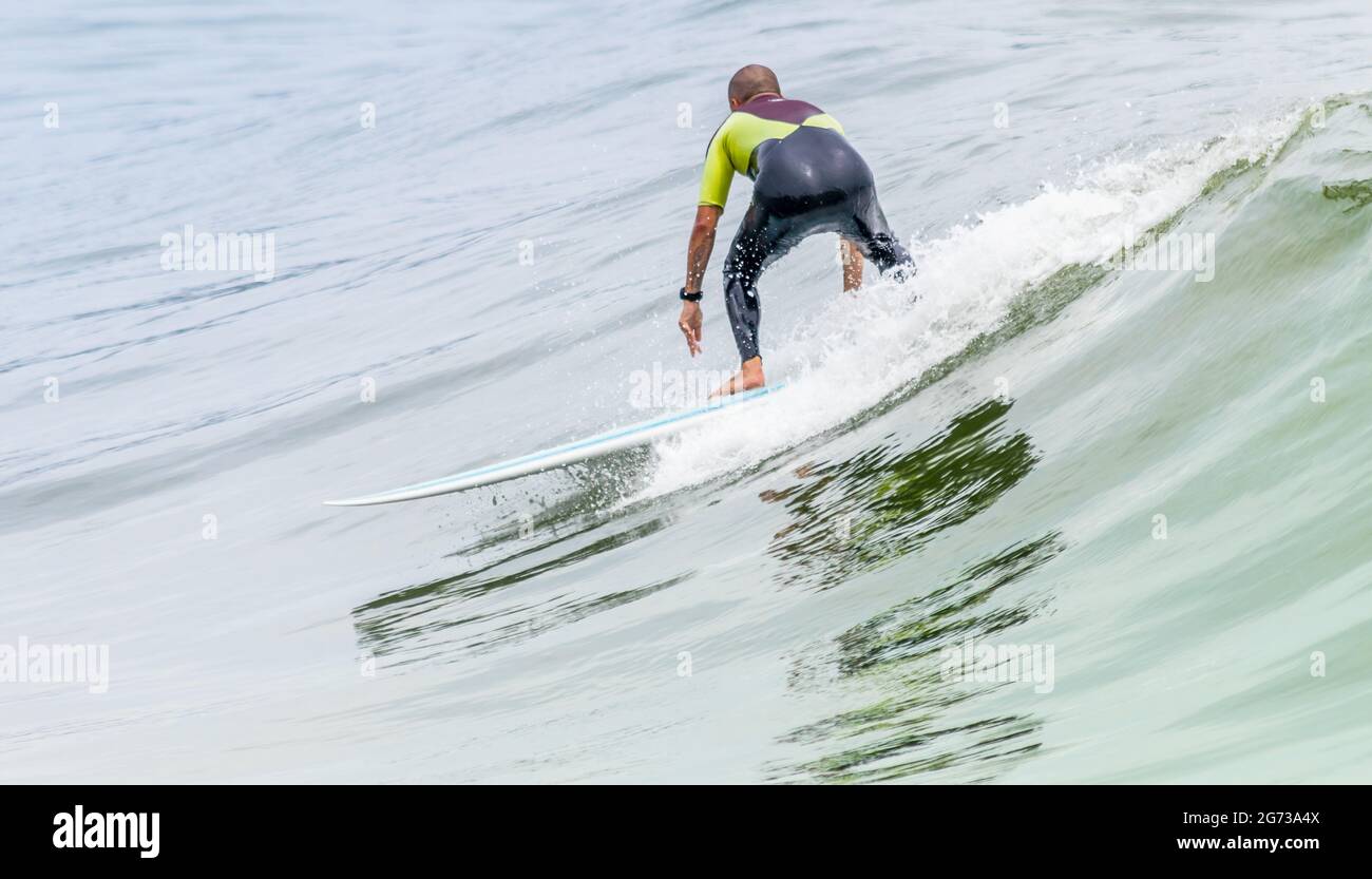 Back view of a young fit person surfing on the waves Stock Photo - Alamy