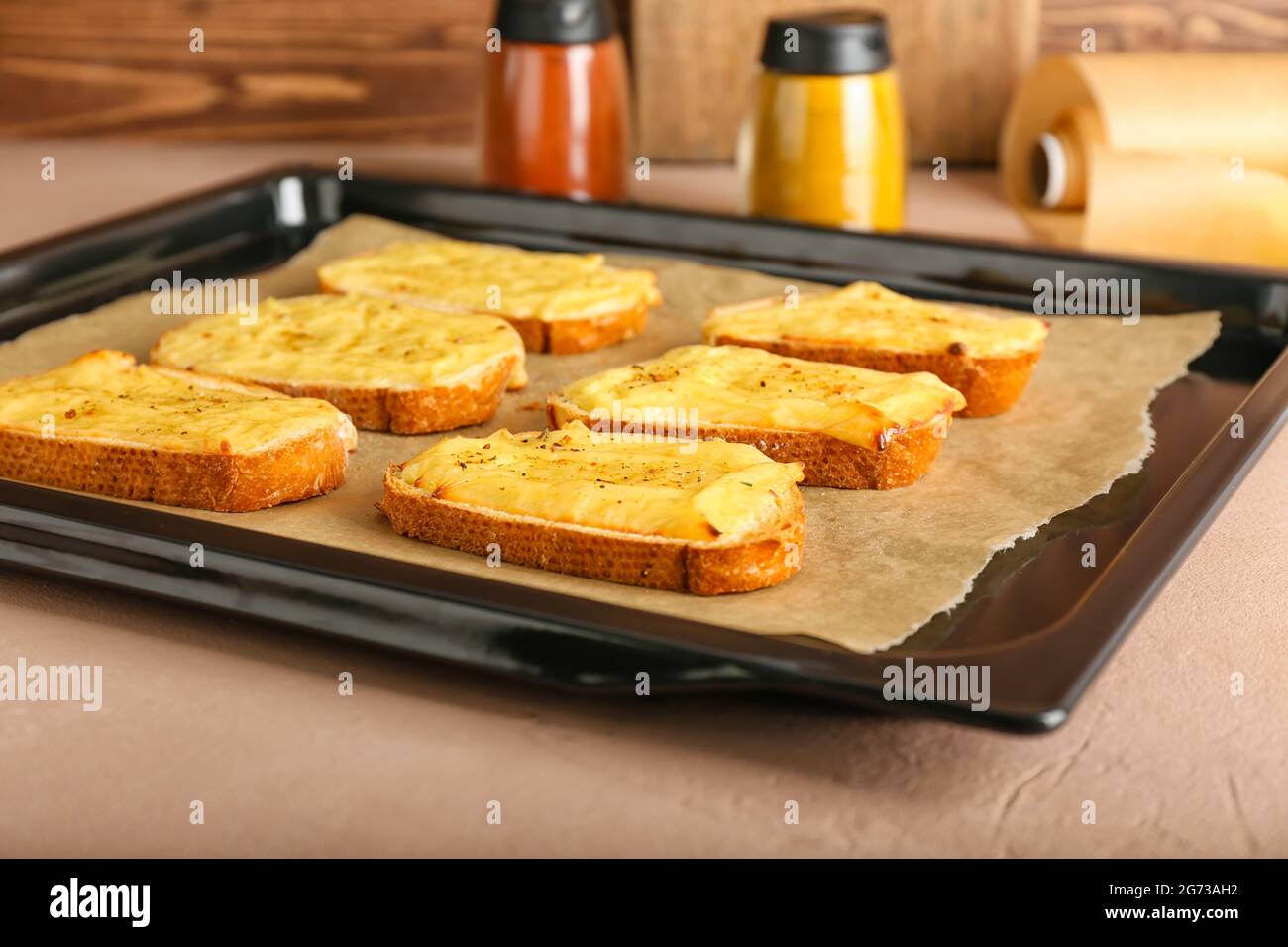 Baking sheet with tasty toasts on kitchen table Stock Photo - Alamy