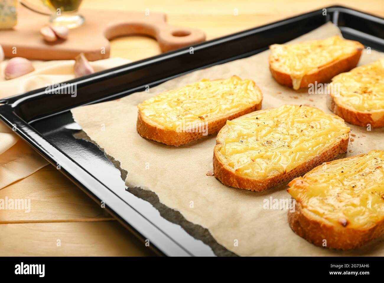 Baking sheet with tasty toasts on wooden background Stock Photo - Alamy