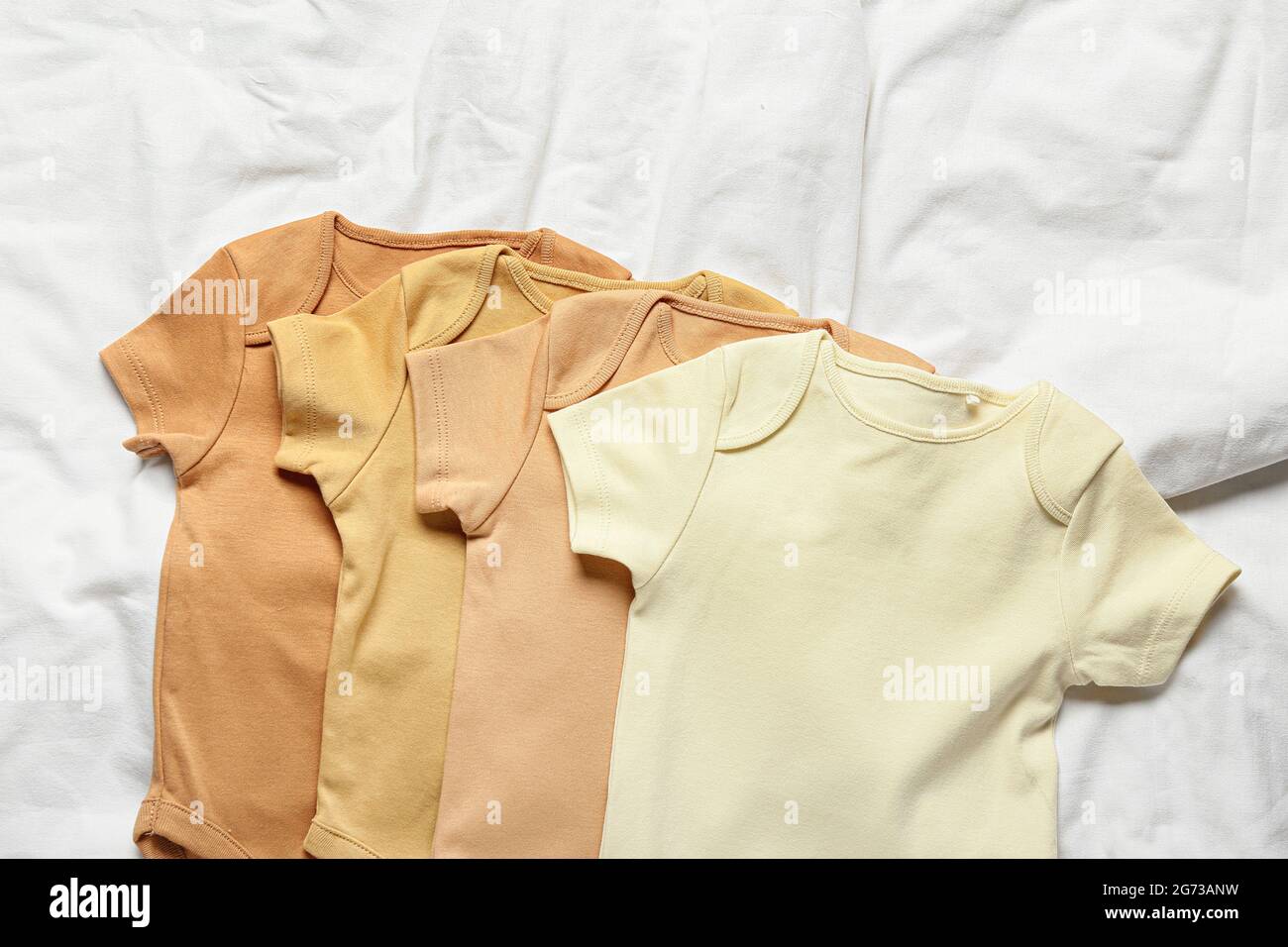 Different baby clothes on bed Stock Photo - Alamy