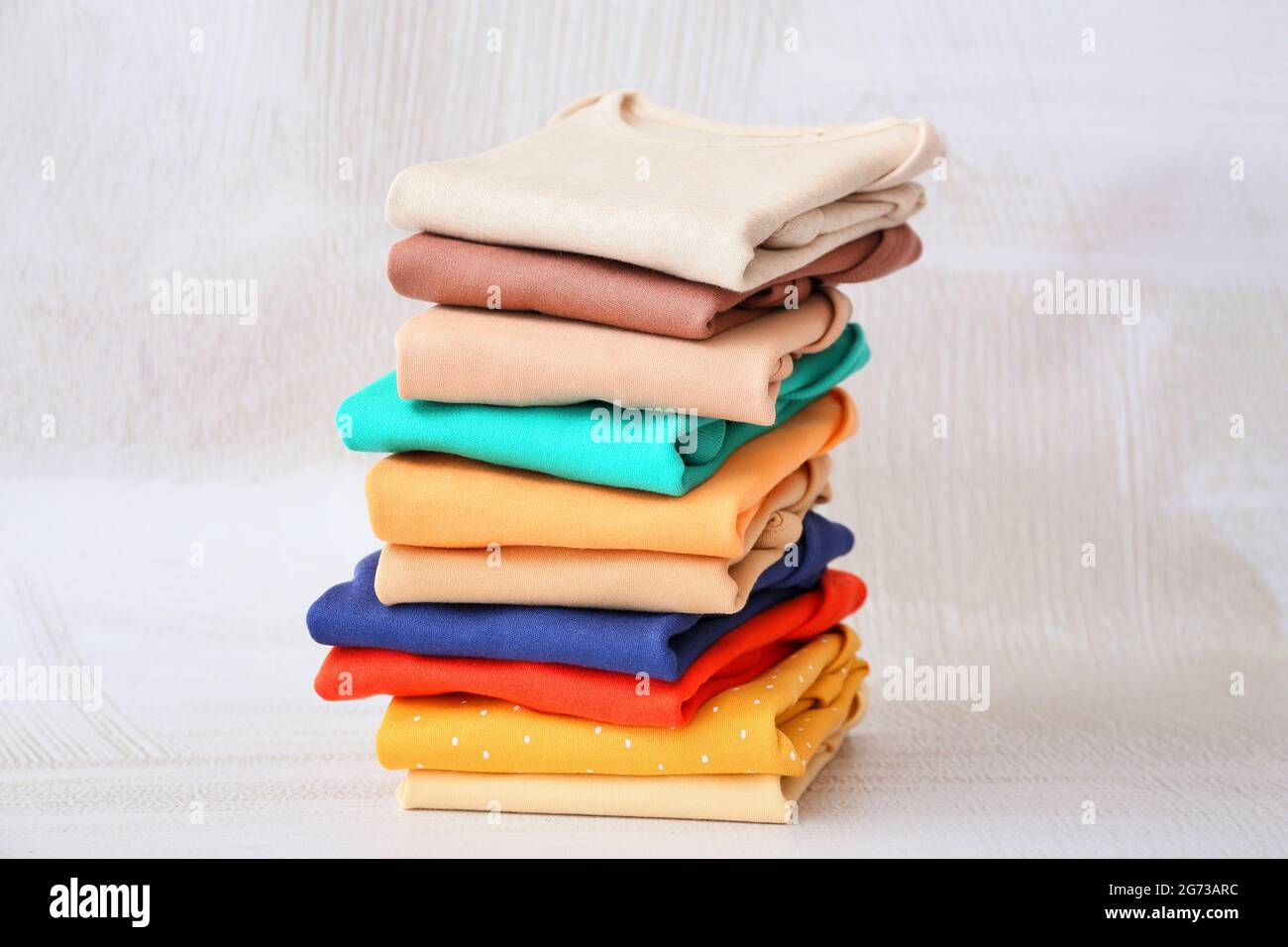 Stack of baby clothes on light background Stock Photo - Alamy