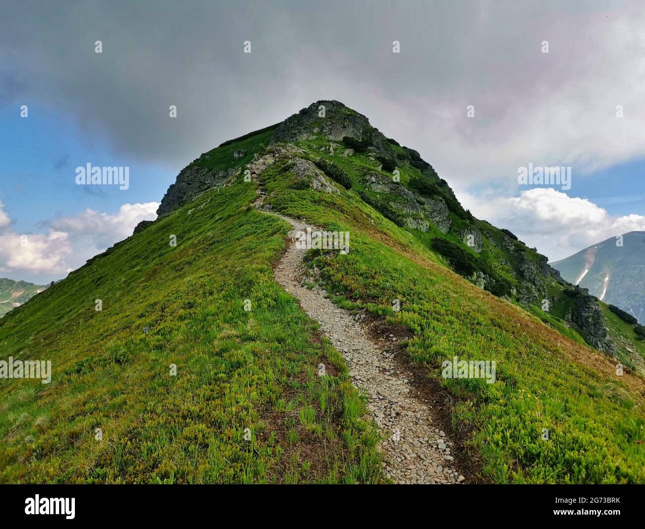 A narrow path on a mountain ridge below the Ostredok peak in the ...