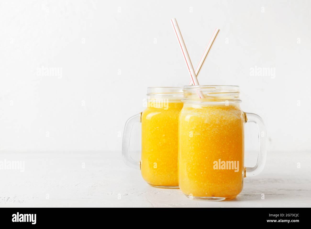 Mason jars of tasty pineapple smoothie on white background Stock Photo ...