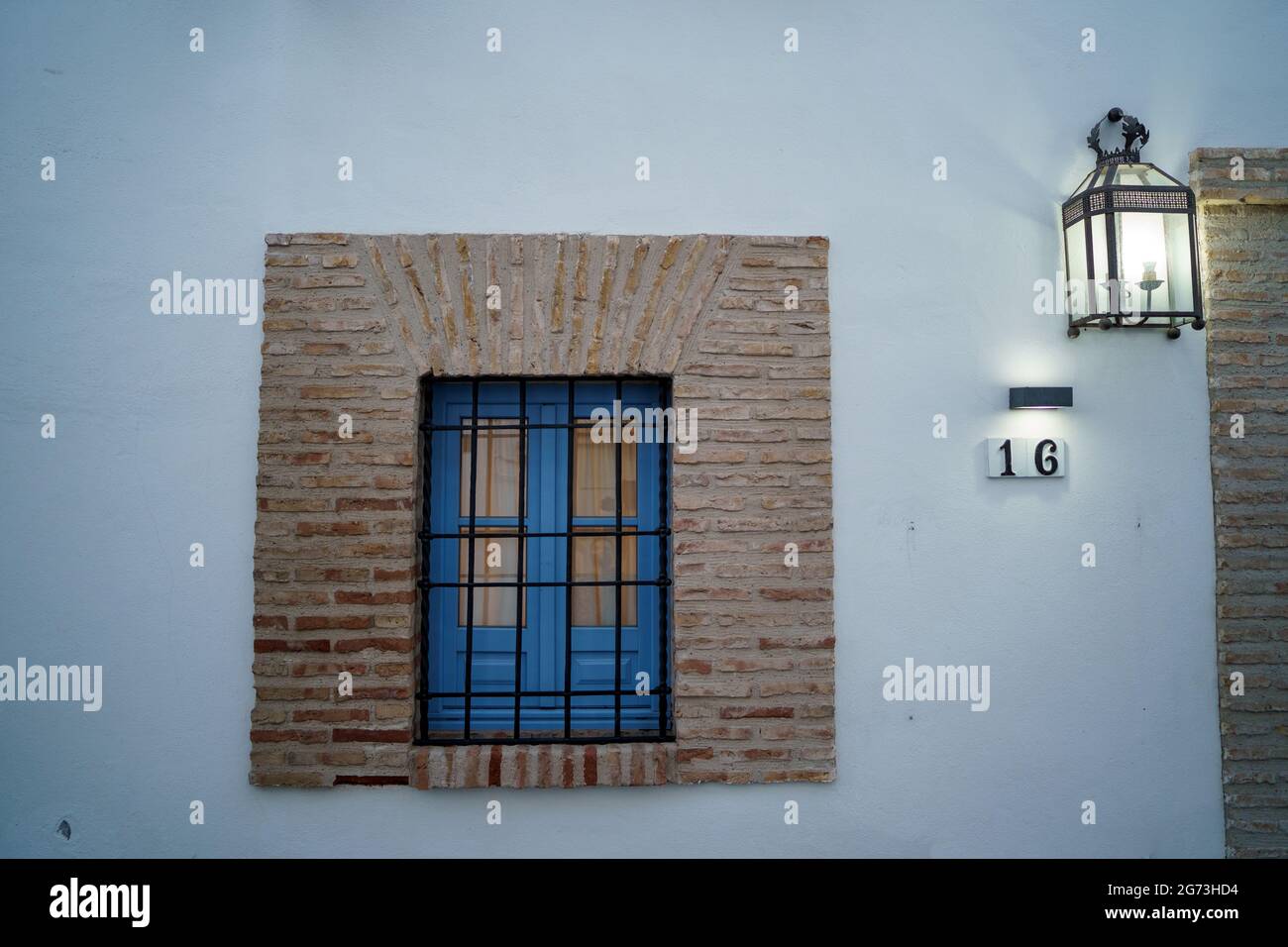 Blue window in a brick wall and lan Stock Photo - Alamy