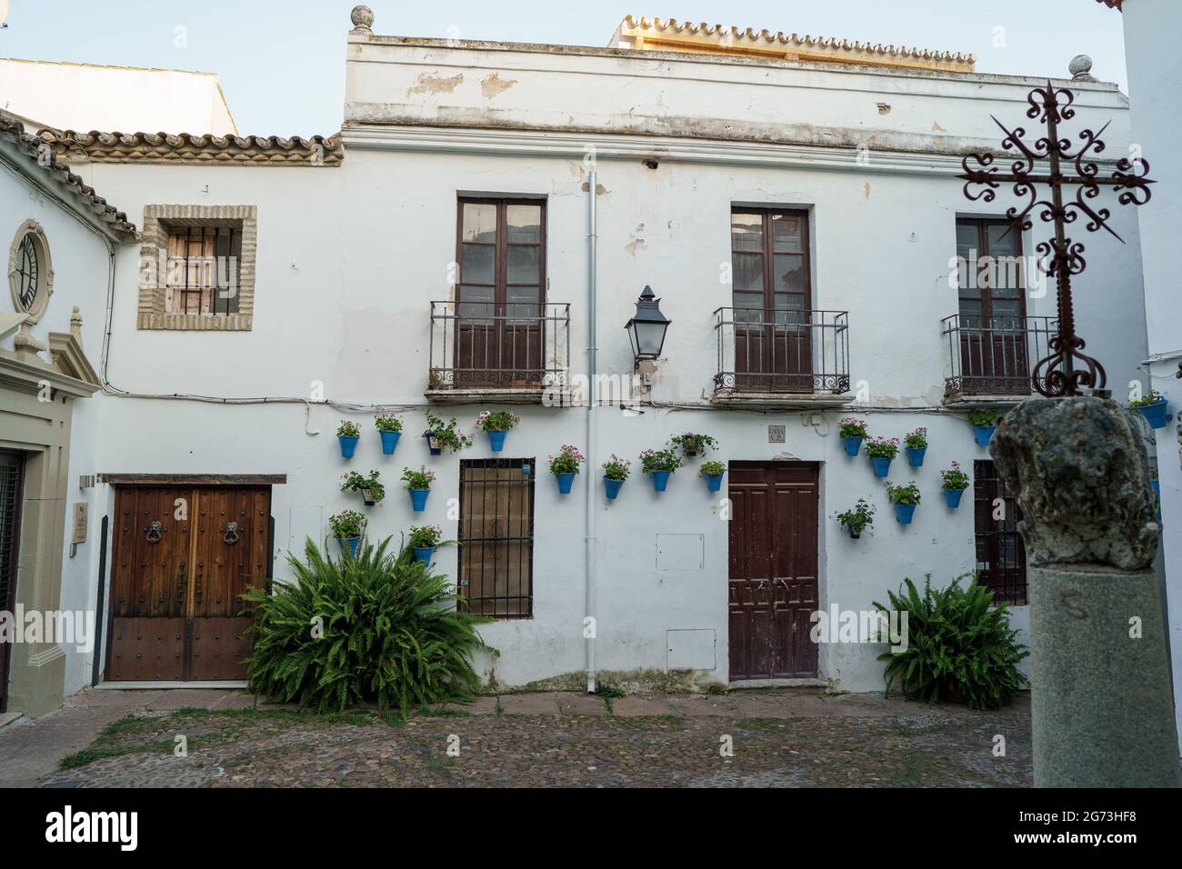 White building with a brown gate, windows and balcony Stock Photo - Alamy