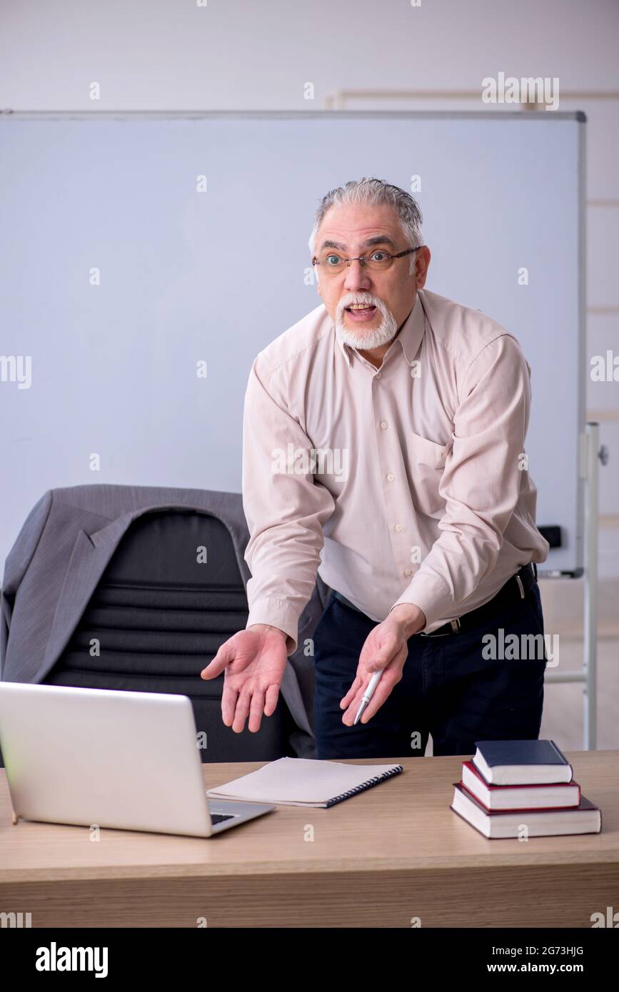 Old teacher in front of whiteboard Stock Photo - Alamy