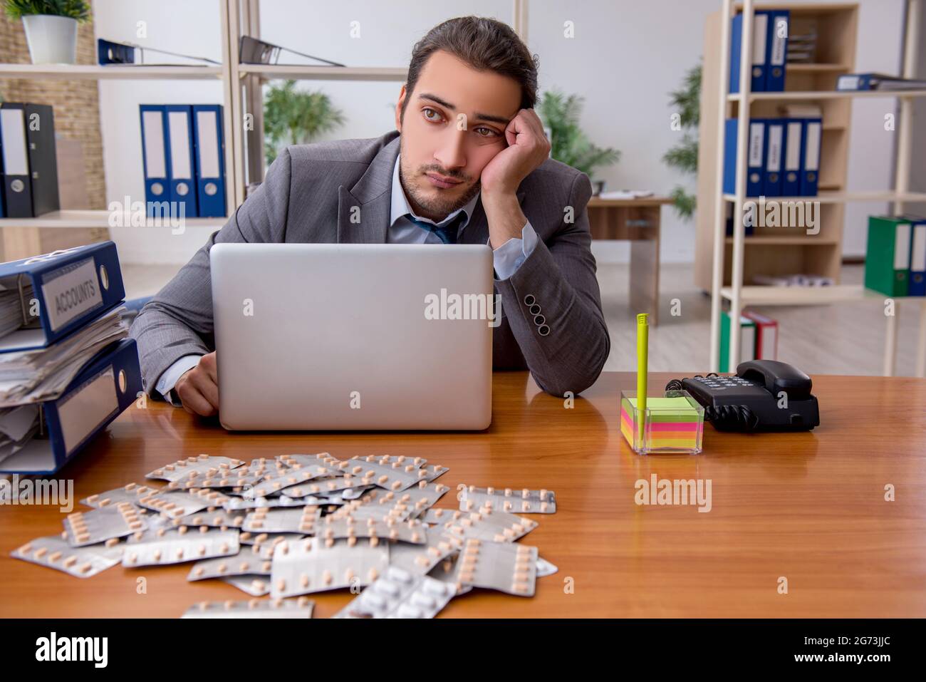Male sick employee suffering at workplace Stock Photo - Alamy