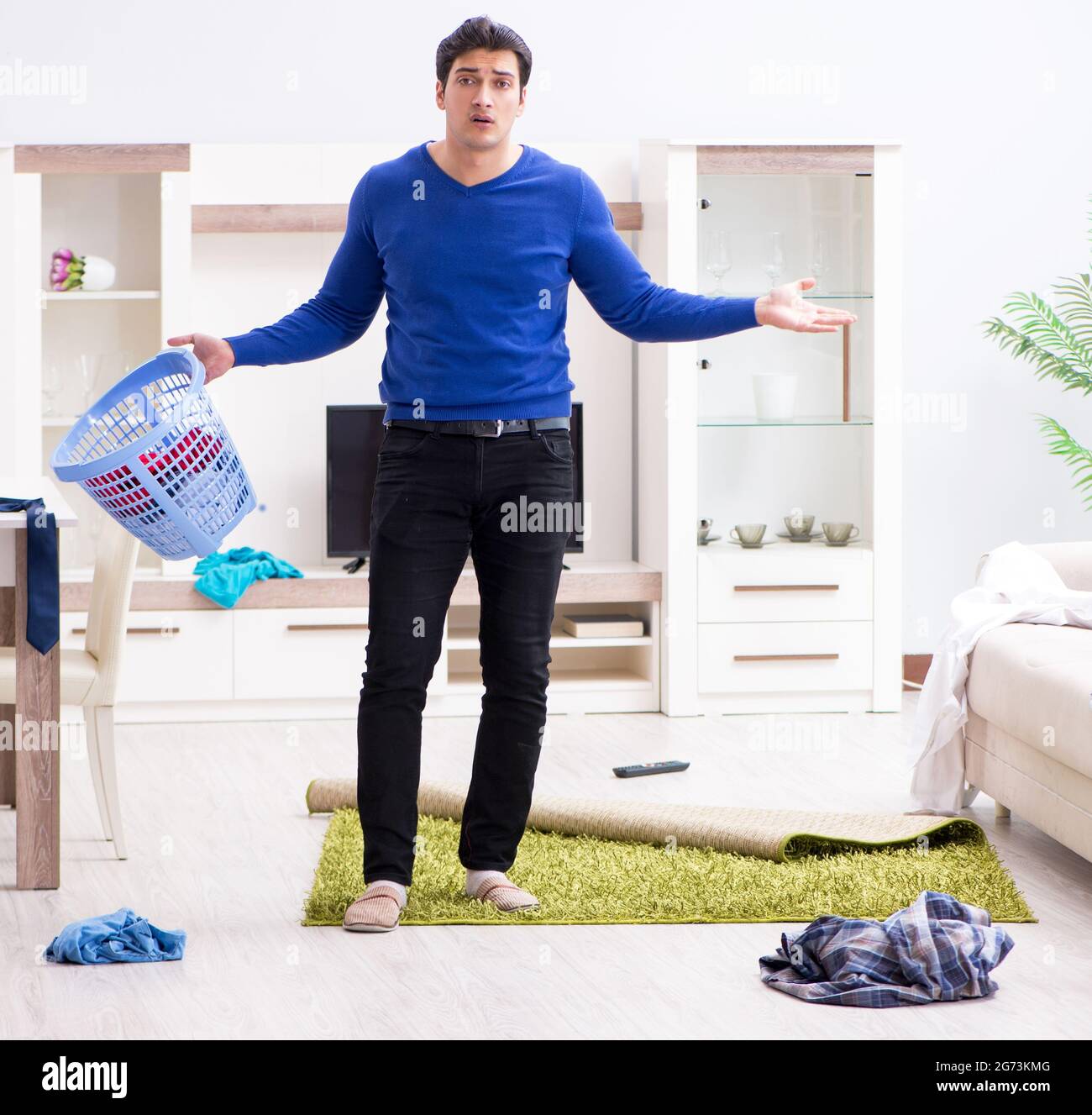The young man collecting dirty clothing for laundry Stock Photo - Alamy