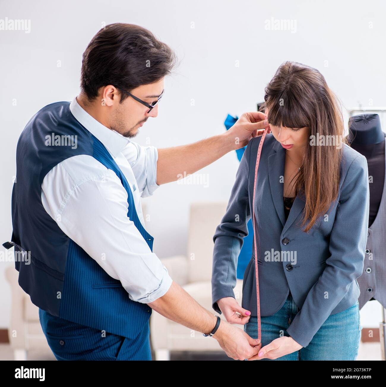 The professional tailor taking measurements for formal suit Stock Photo ...