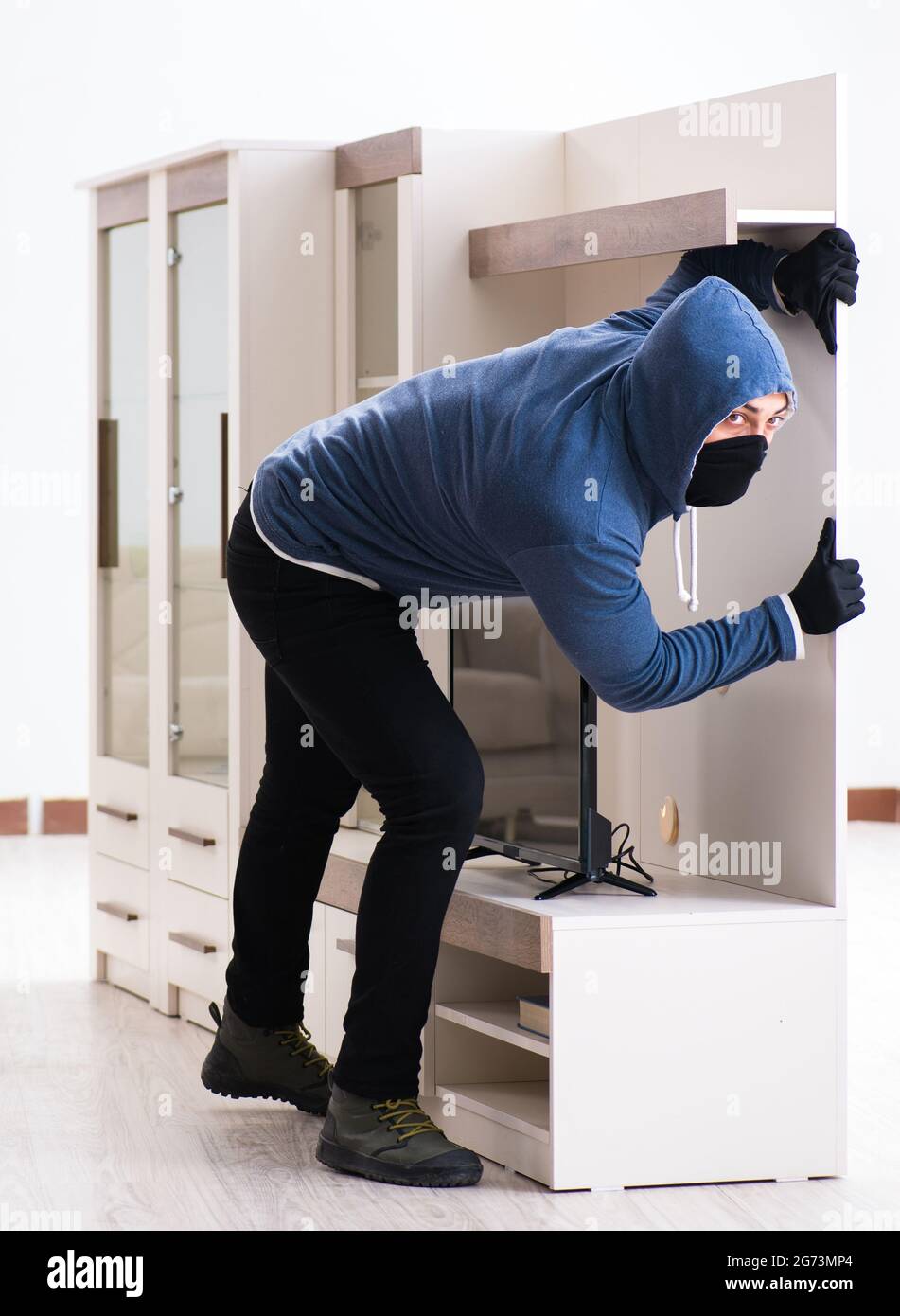 The man burglar stealing tv set from house Stock Photo - Alamy