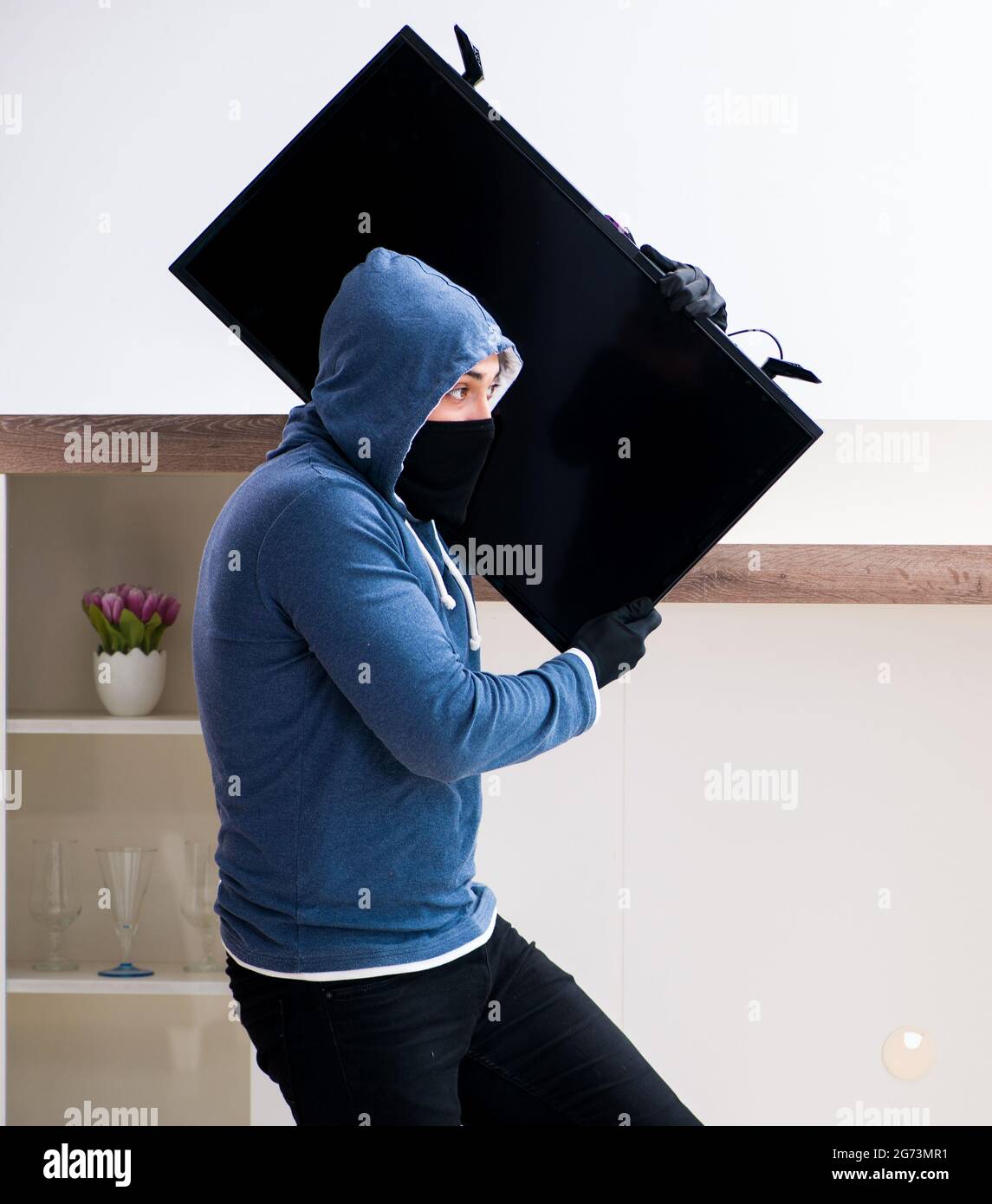 The man burglar stealing tv set from house Stock Photo - Alamy