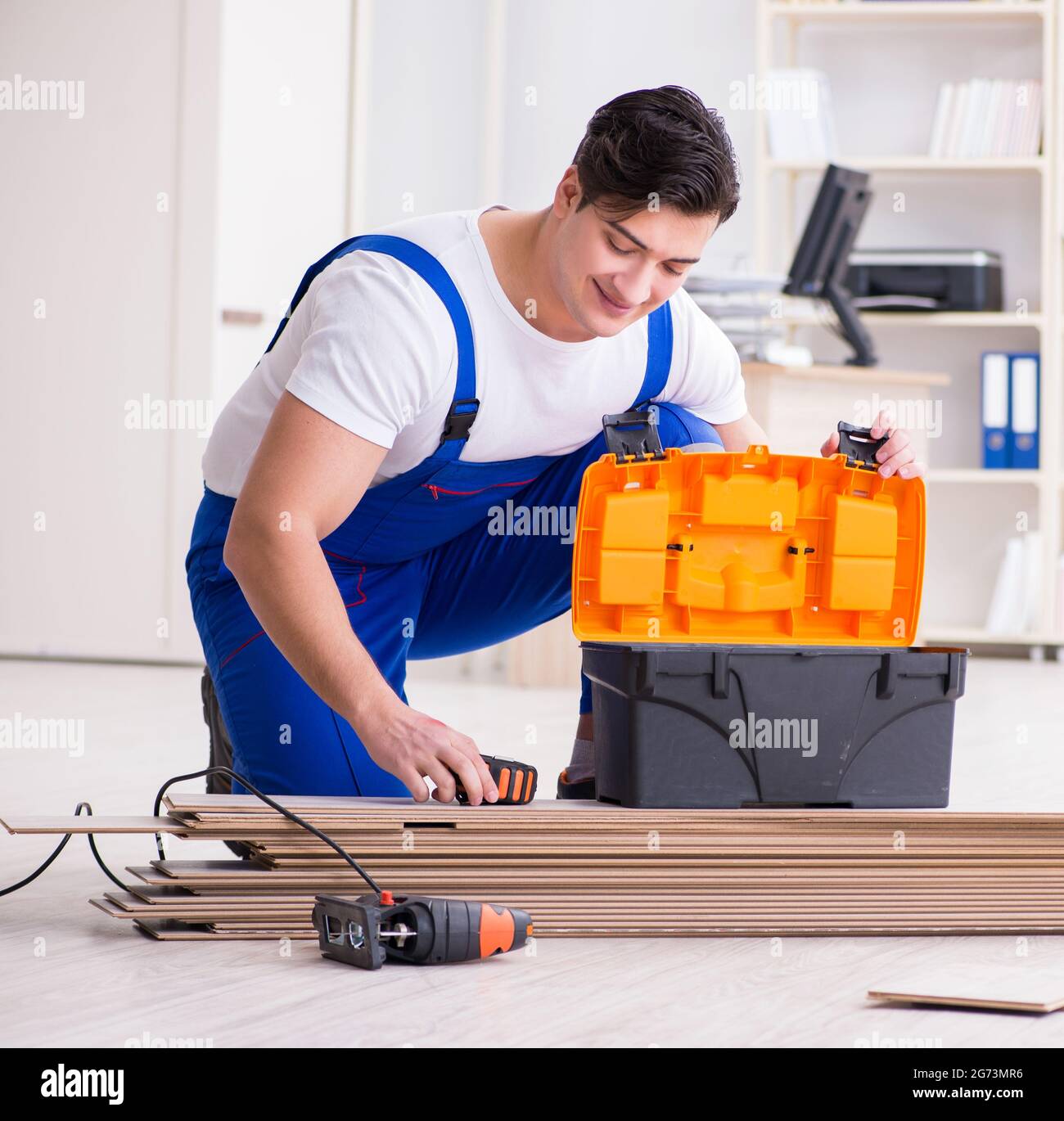 The young worker working on floor laminate tiles Stock Photo - Alamy