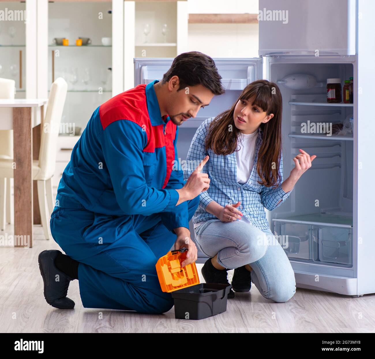 The man repairing fridge with customer Stock Photo - Alamy