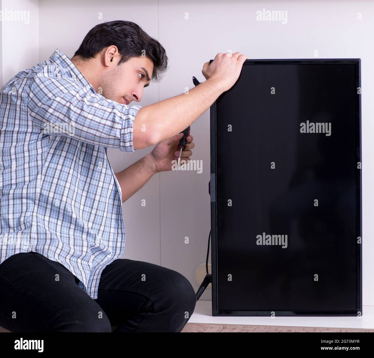 The man repairing broken tv at home Stock Photo - Alamy