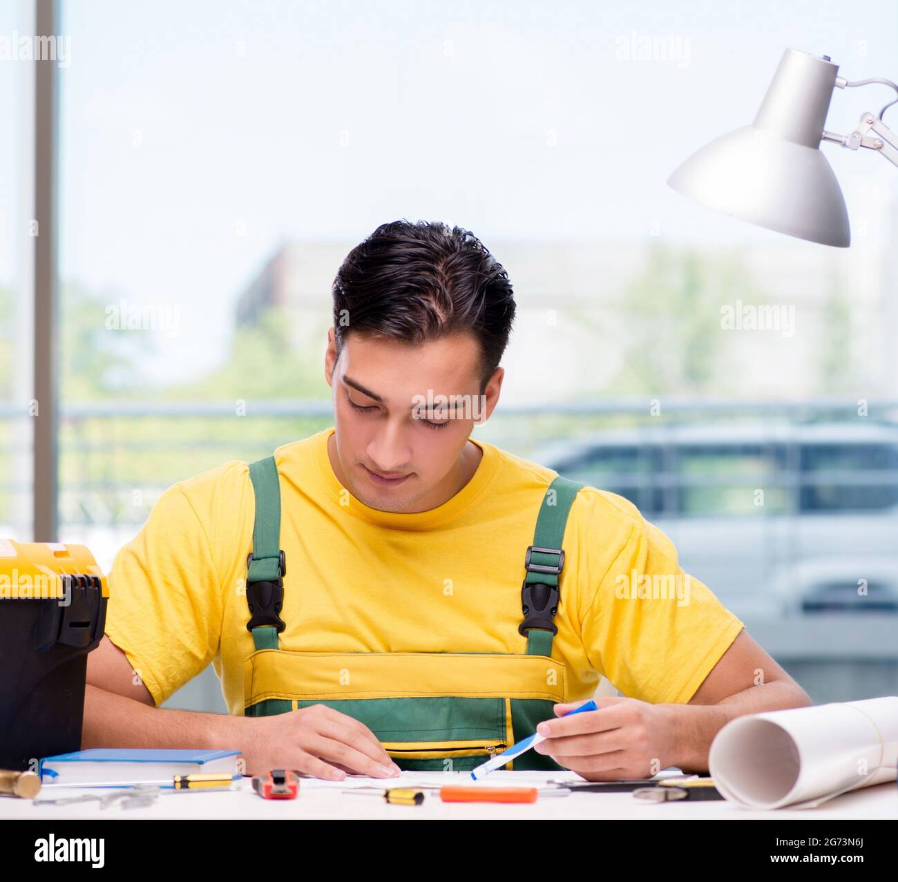 The construction worker sitting at the desk Stock Photo - Alamy