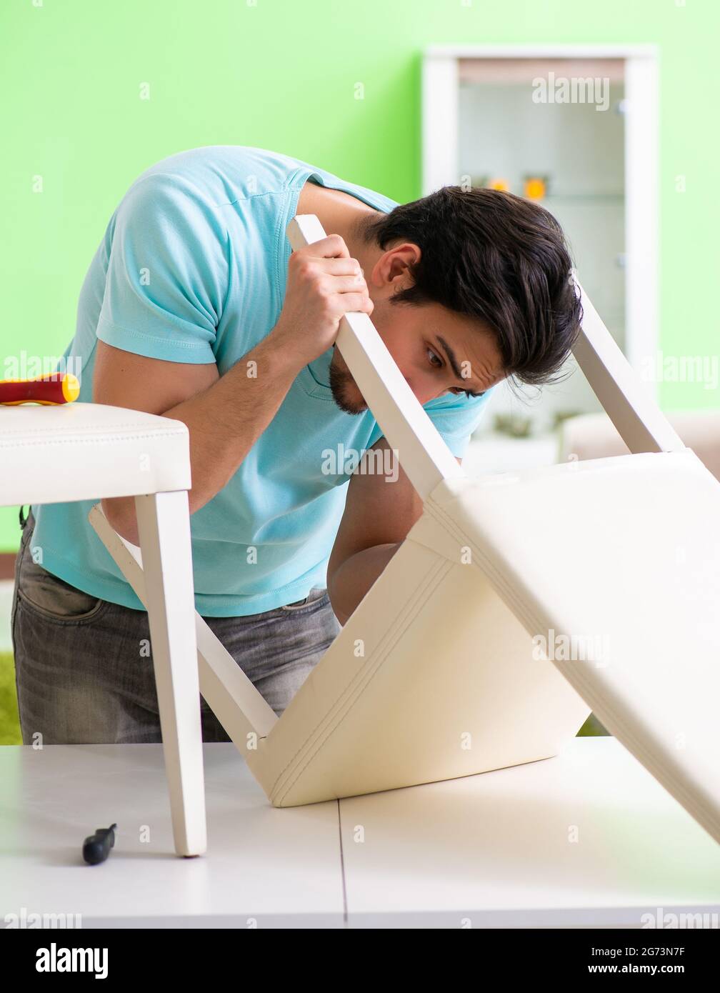 The man repairing furniture at home Stock Photo - Alamy